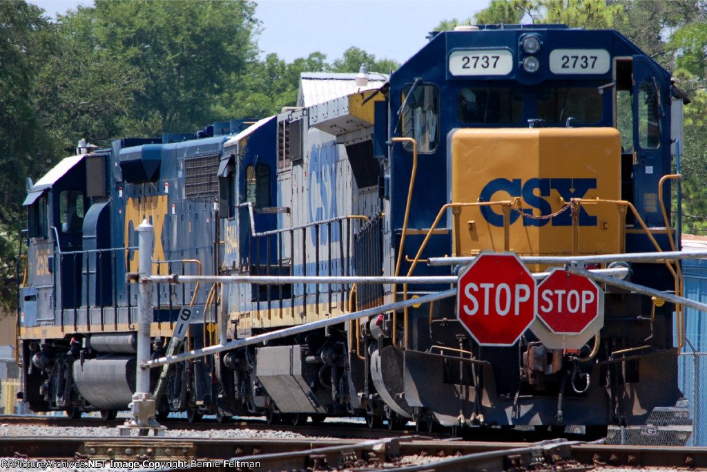 CSX GP38-2 #2737, B40-8 #5944 and GP38-2 #2515 sit on the south side of the crossing with the ...